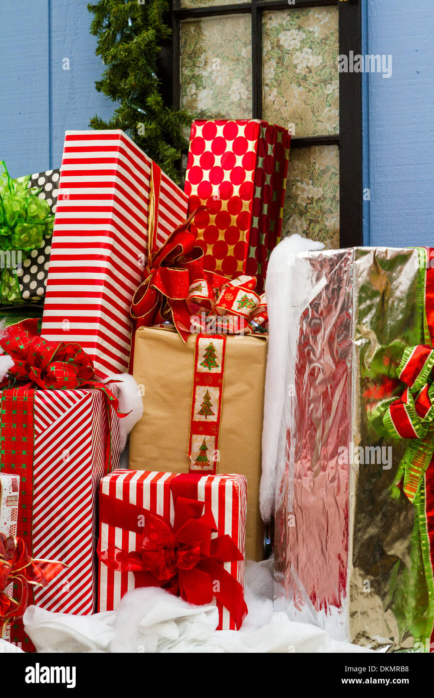 Large presents wrapped in colorful papers with bows in a pile ready for ...