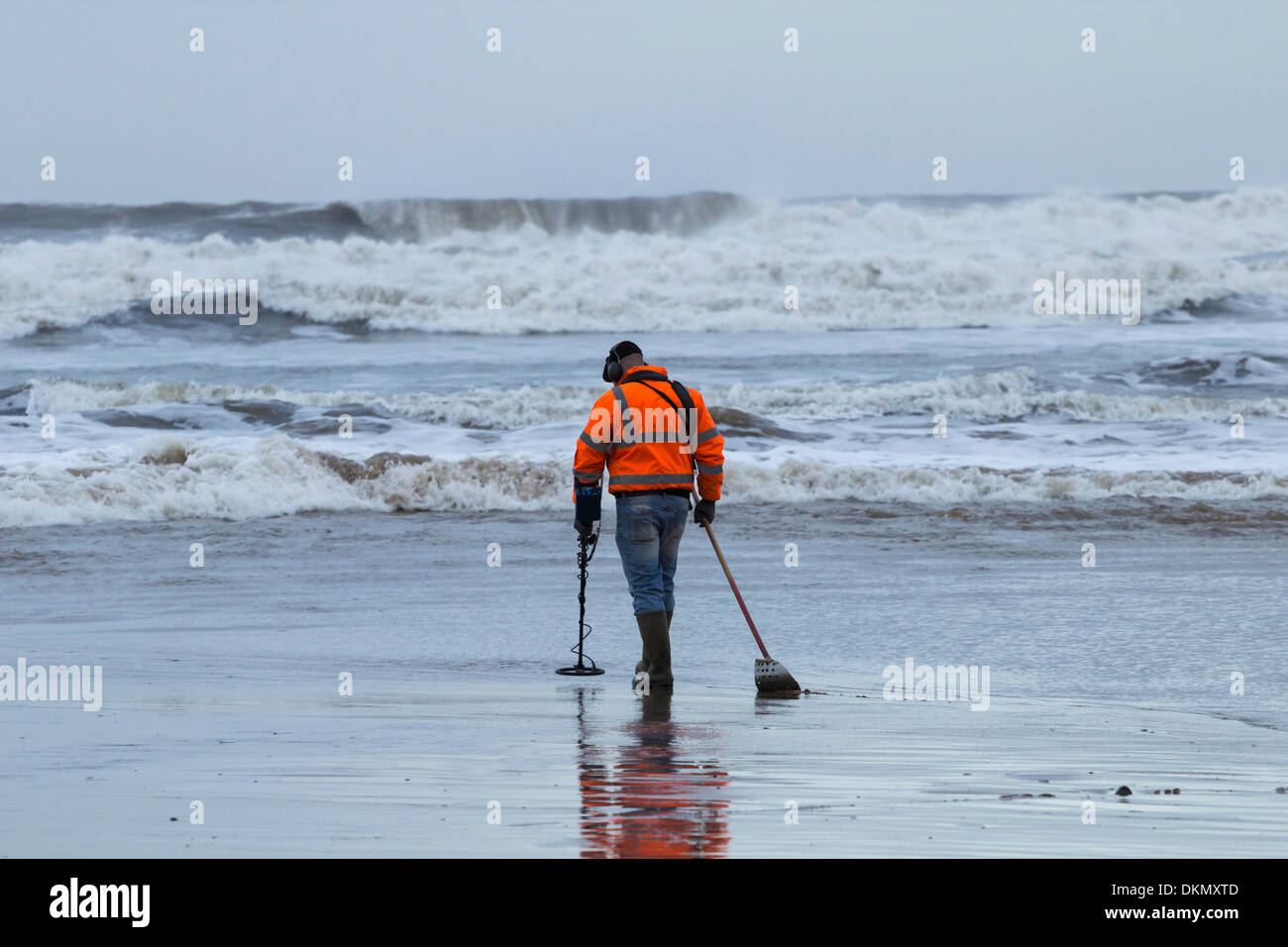 Man metal detecting with metal detector on beach. UK Stock Photo - Alamy