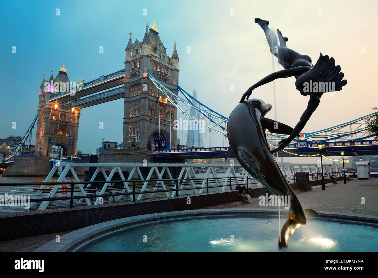 Tower Bridge and statue of a girl playing with dolphin in St Katharine ...