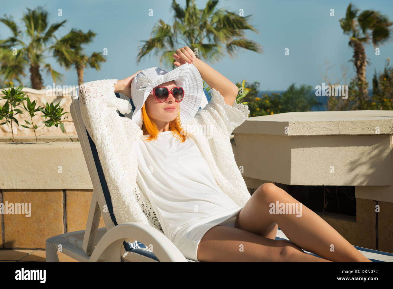 Young woman enjoying sun on sunbed at tourist resort Stock Photo - Alamy