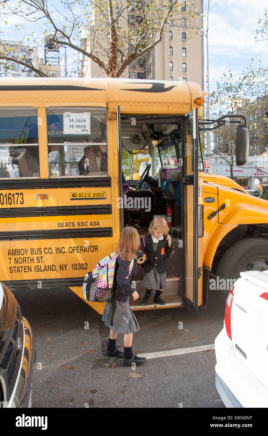Young children getting off an American school bus in Manhattan NYC USA ...