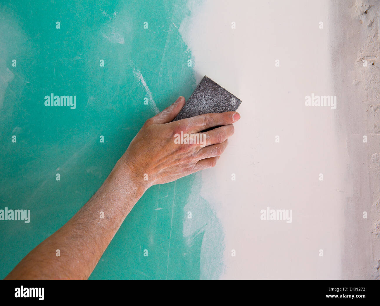 plastering man hand sanding the plaste in drywall seam plasterboard ...
