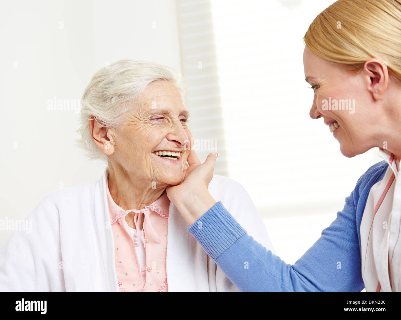Daughter caressing happy senior mother with her hand over her cheek ...