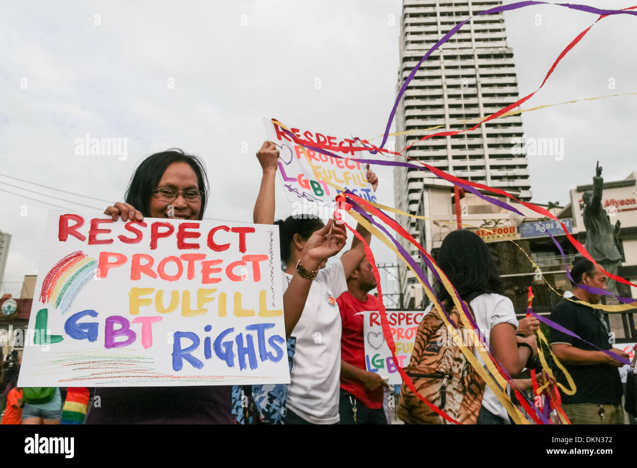 Manila, Philippines. 7th Dec, 2013. Gay Pride attendees display posters ...