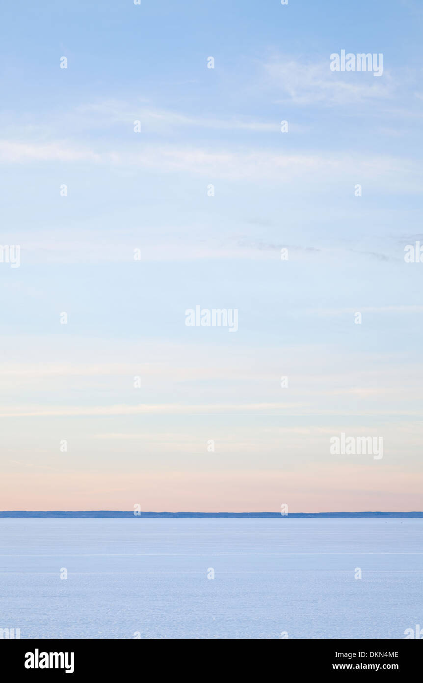 A simple view of a frozen Lake Simcoe with wispy clouds in a blue sky ...