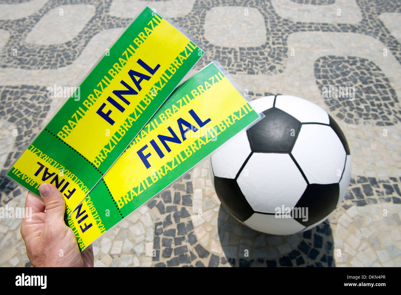 Fan holds two tickets to the football match above soccer ball in Rio de ...