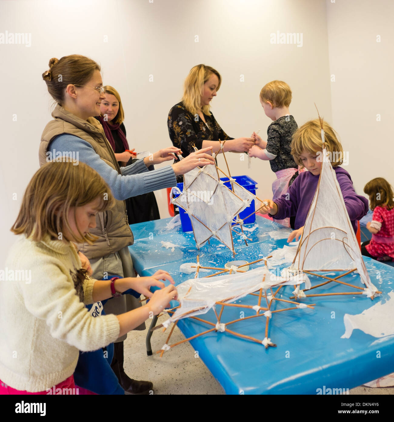 Parents and children having messy fun at a Christmas lantern making ...