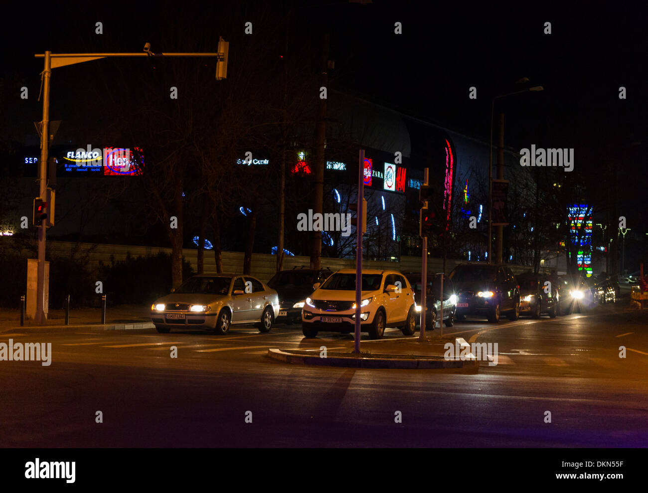 Cars stopped at red light as pedestrians cross the road - night view ...