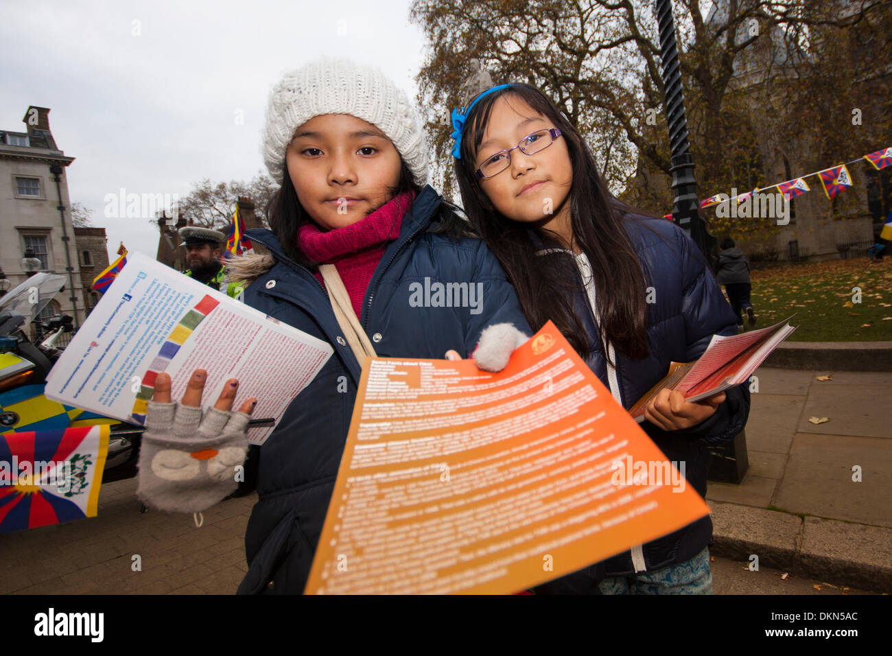 London, UK. 7th Dec 2013. Two girls hand out leaflets as Tibetans ...