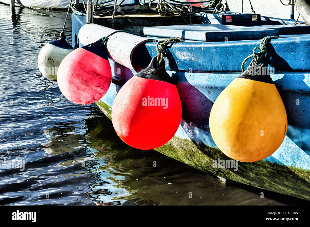 Colorful buoys attached to the side of a boat. Mousehole Harbor ...