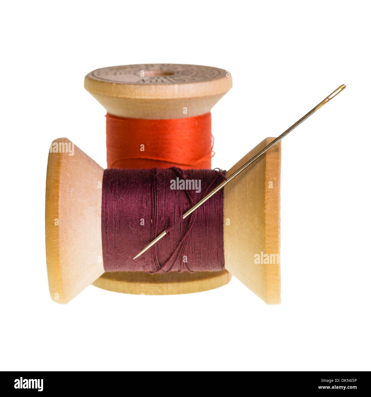 Two spools of sewing thread with a needle Stock Photo - Alamy
