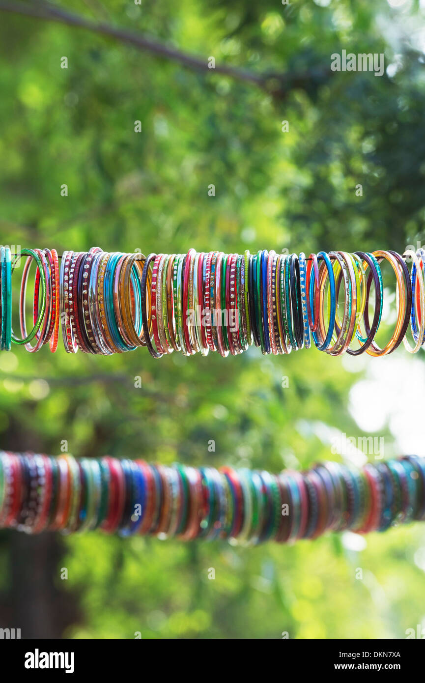 Colourful indian women bangles hanging on a line in front of a hindu ...