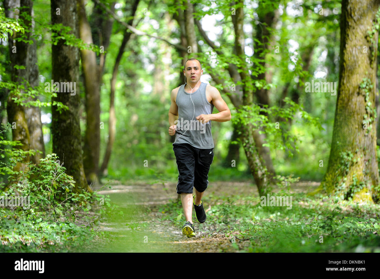 Young man running in the forest Stock Photo - Alamy