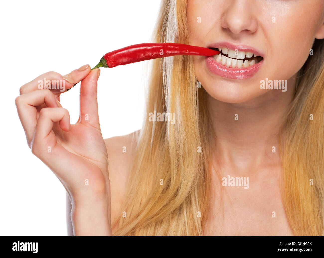 Closeup on teenage girl holding biting red chili pepper Stock Photo - Alamy