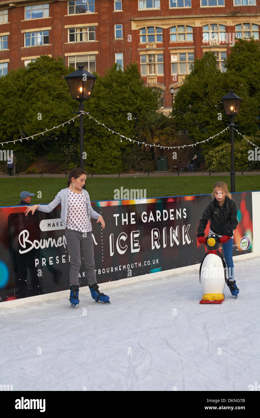 Bournemouth, UK Sunday 8 December 2013. Girls with penguin ice skating ...
