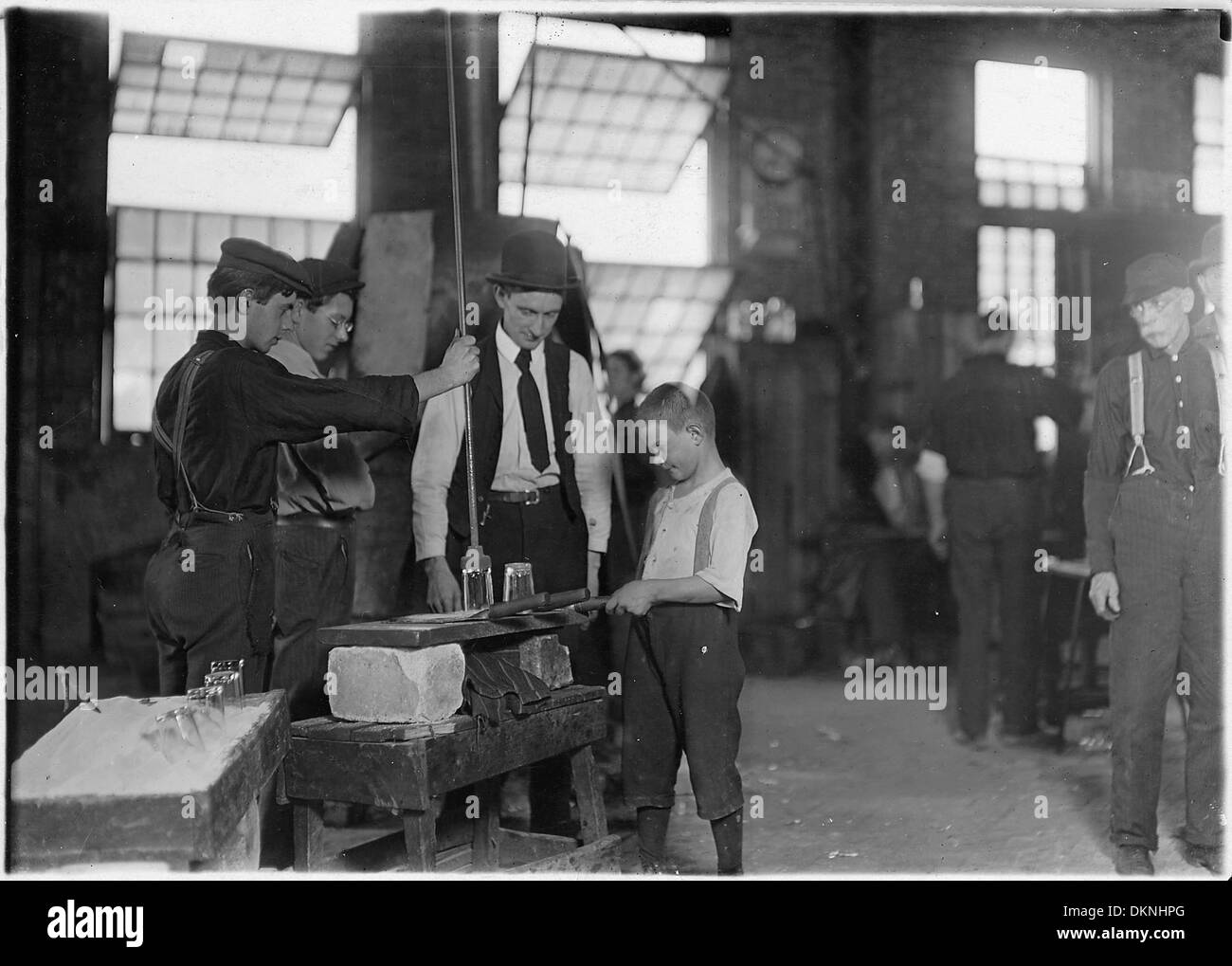 This image shows a seasoned boss demonstrating a skill to a younger ...