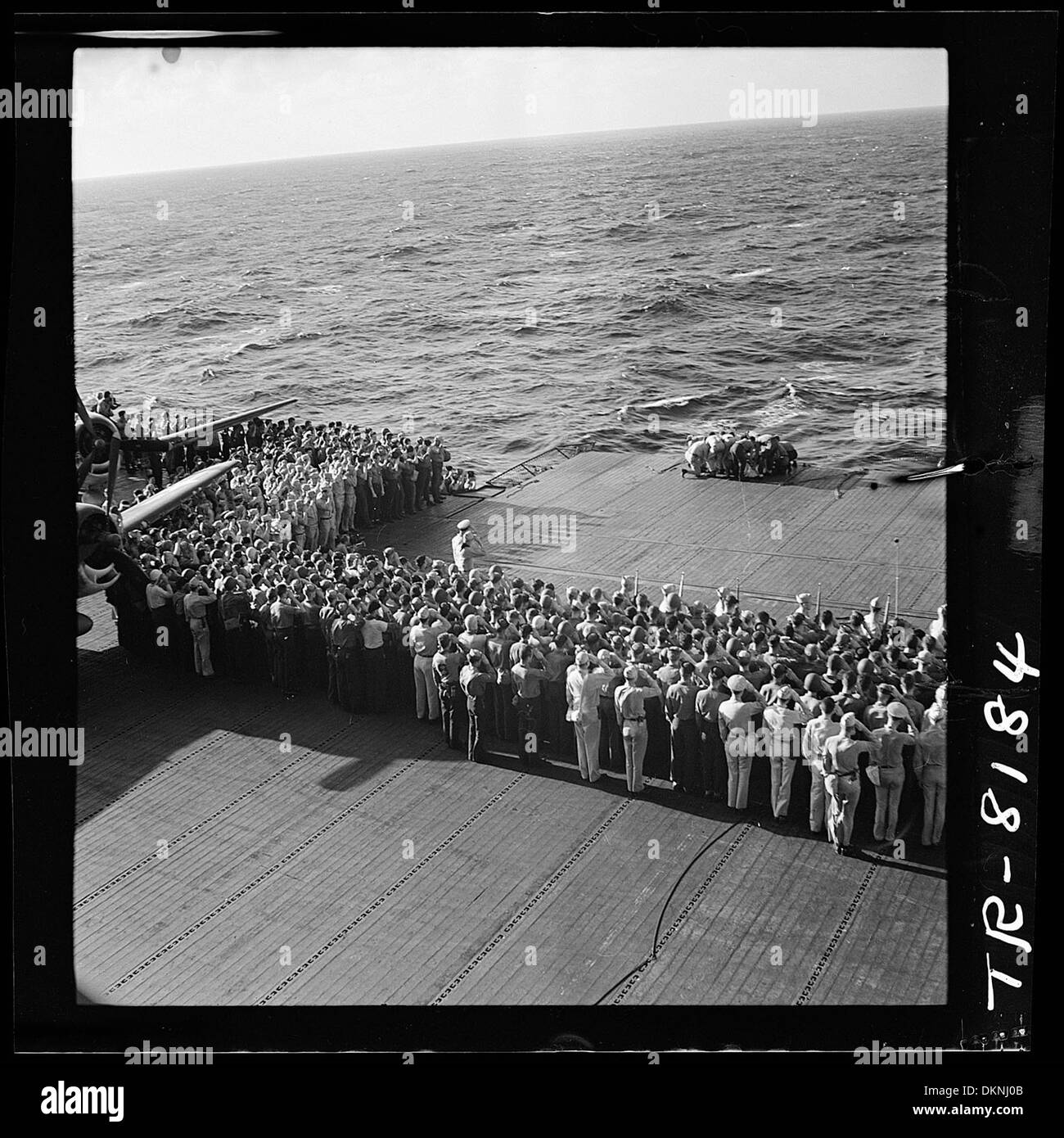 Crew members aboard the USS Lexington, CV-16, attend the burial rites ...