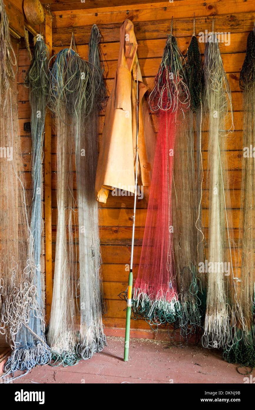 Hanging fishing nets, spinning rod and a jacket on a timber wall Stock ...