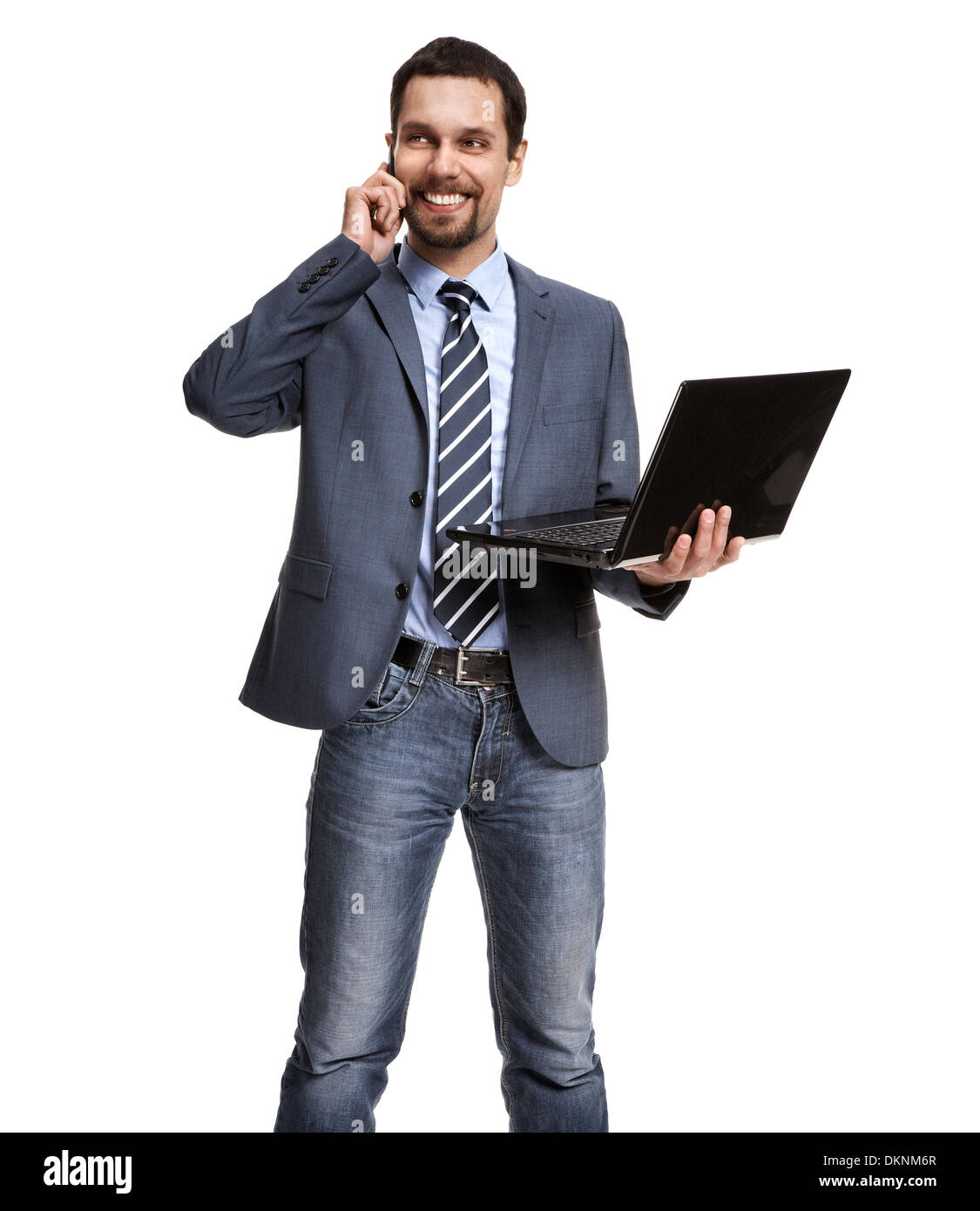 Smiling businessman talking on the phone while working with laptop ...