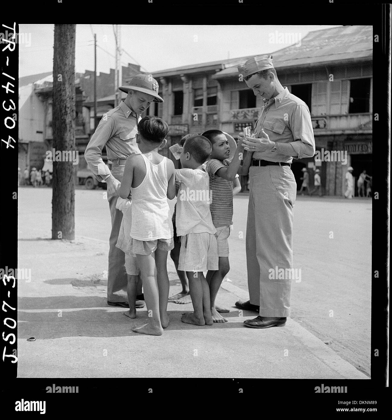 Filipino children make friends with two Naval officers in downtown ...