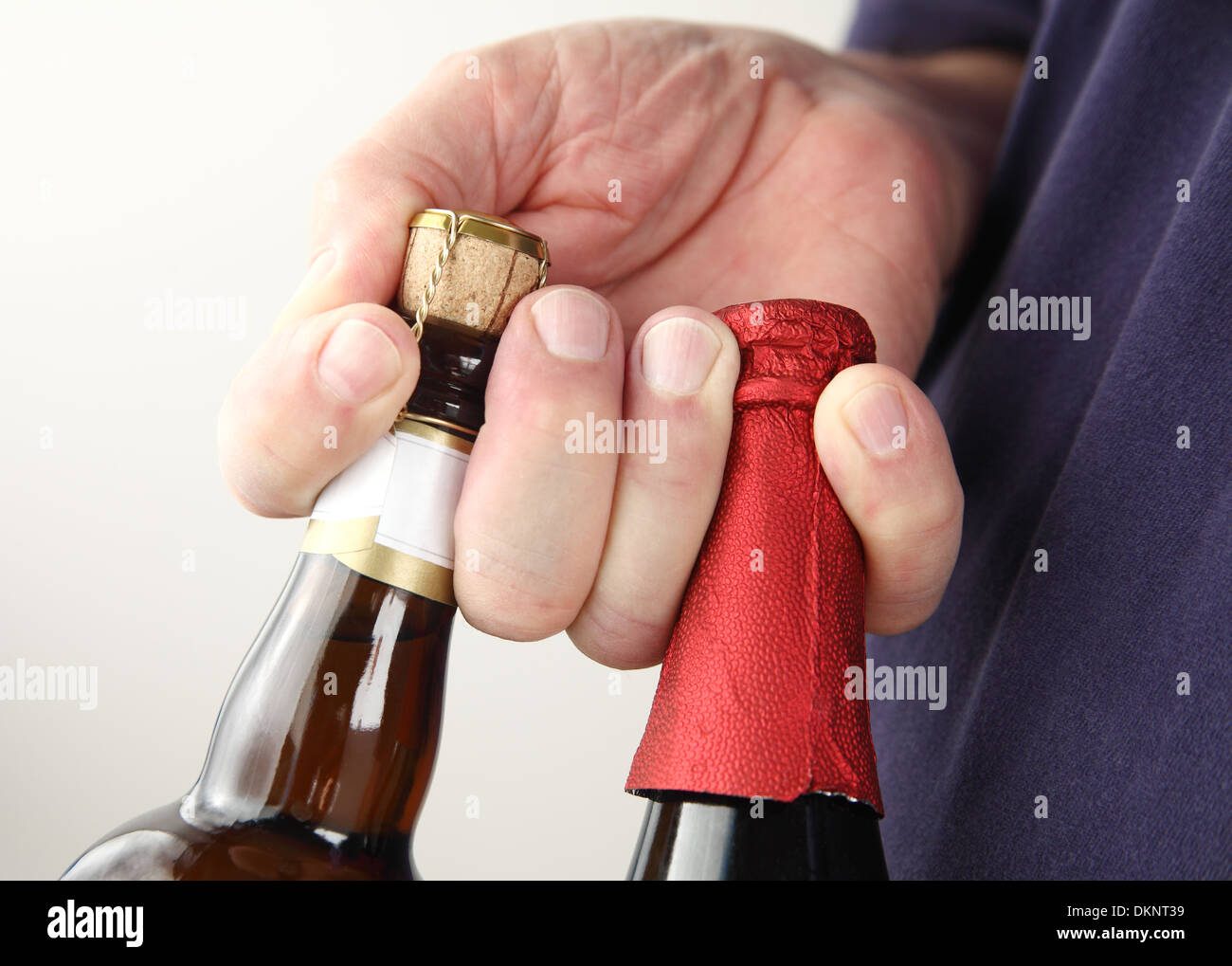 two large beer bottles in man's fingers Stock Photo - Alamy