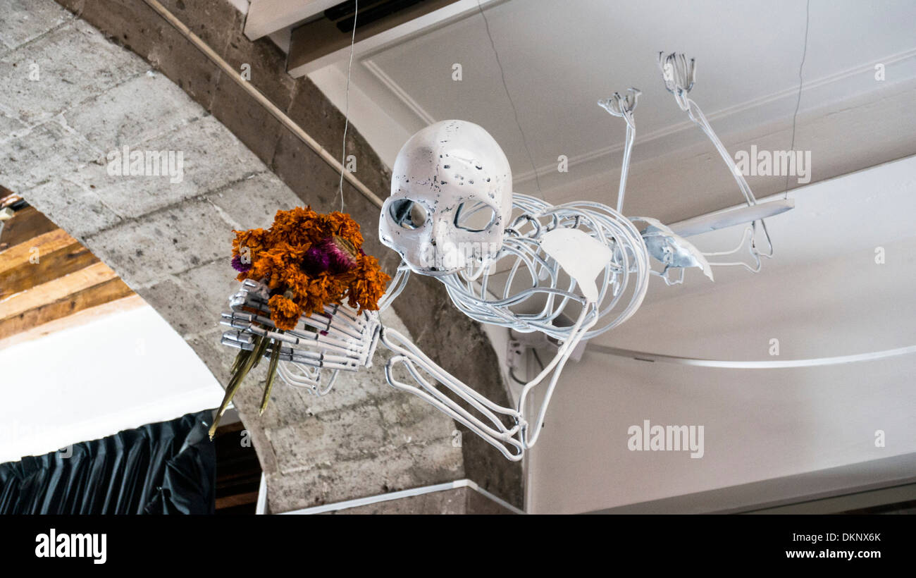 artisanal skeleton on a flying trapeze holding bouquet of dried flowers ...