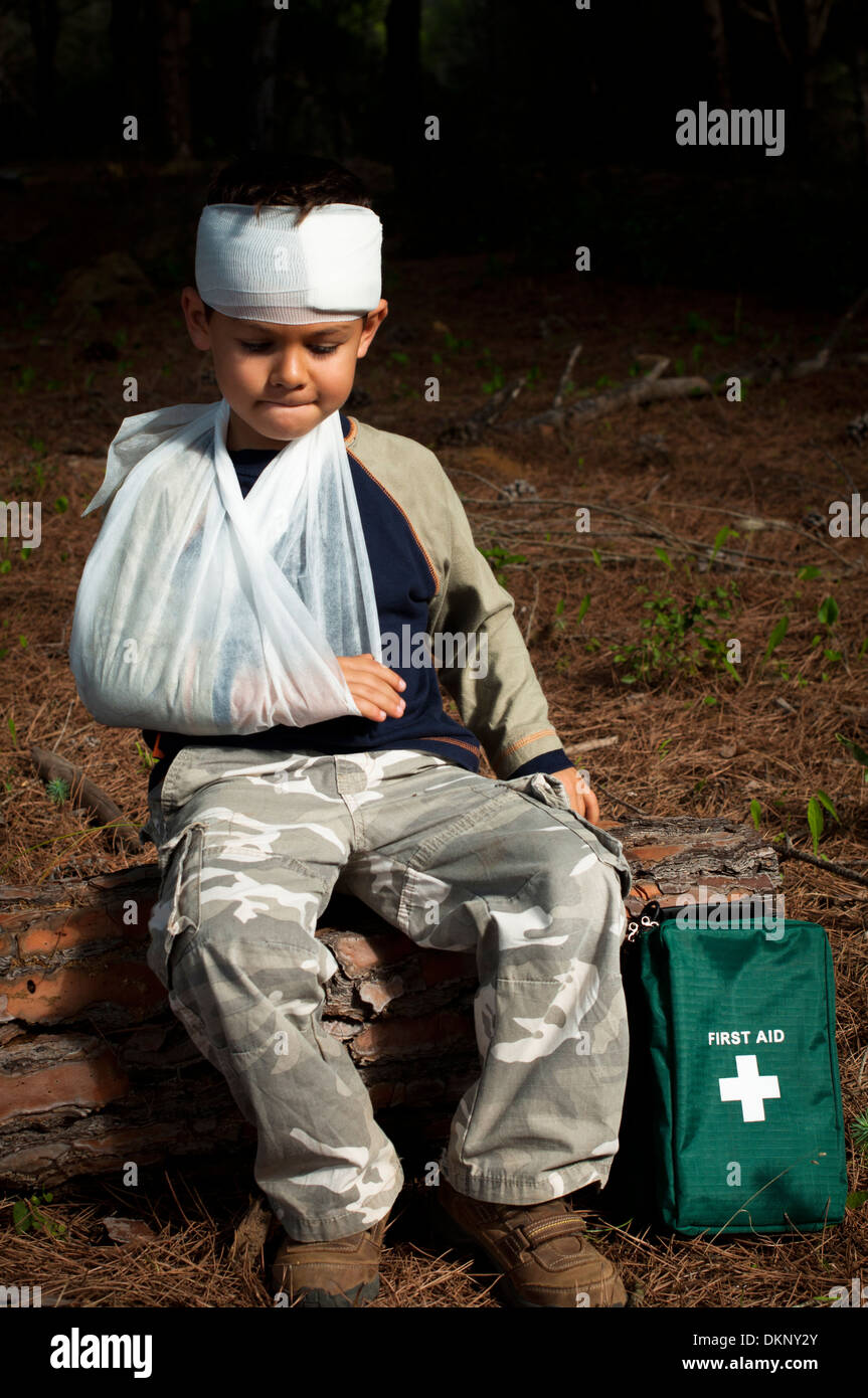 First Aid treatment given to a young boy in the forest, showing an arm ...