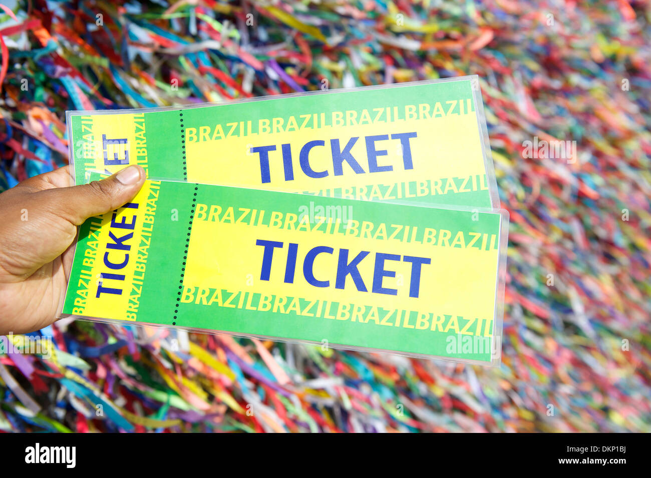 Hand holding tickets in front of background of colorful Brazilian ...