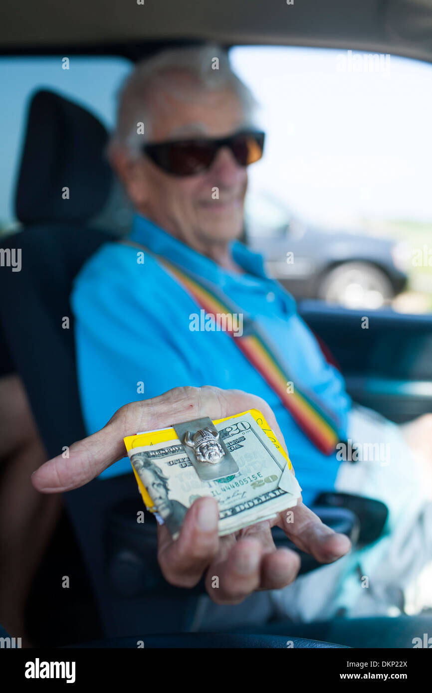 An old taxi driver, born on Block Island, displays a clip of dollars in ...