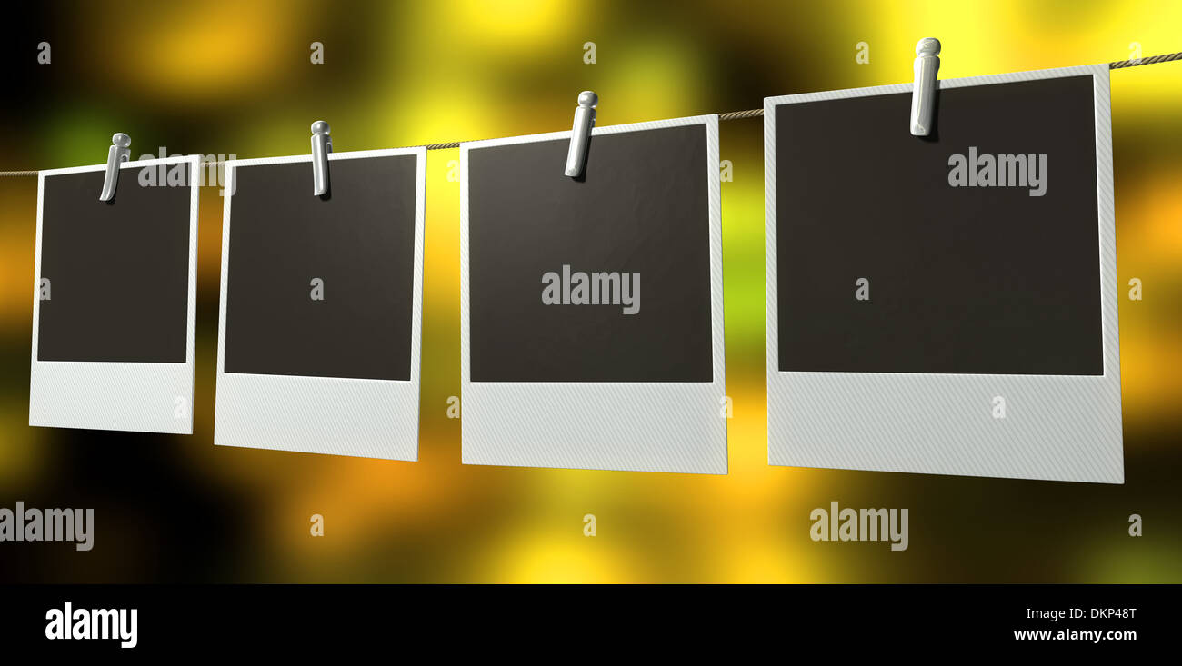 A gallery of four blank polaroids pegged onto a string on a blurry ...