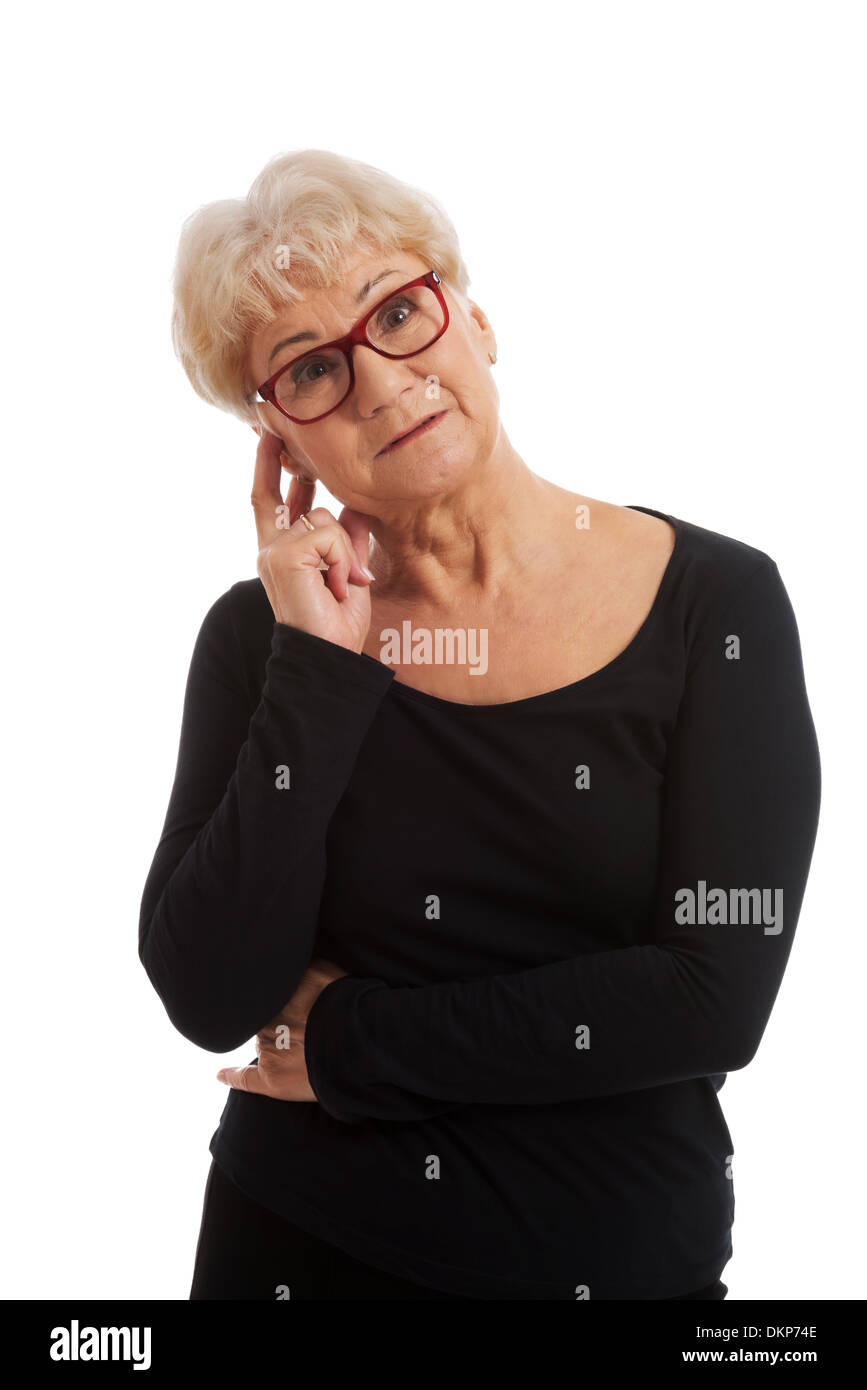 An old lady in eyeglasses touches her face in contemplation. Isolated ...