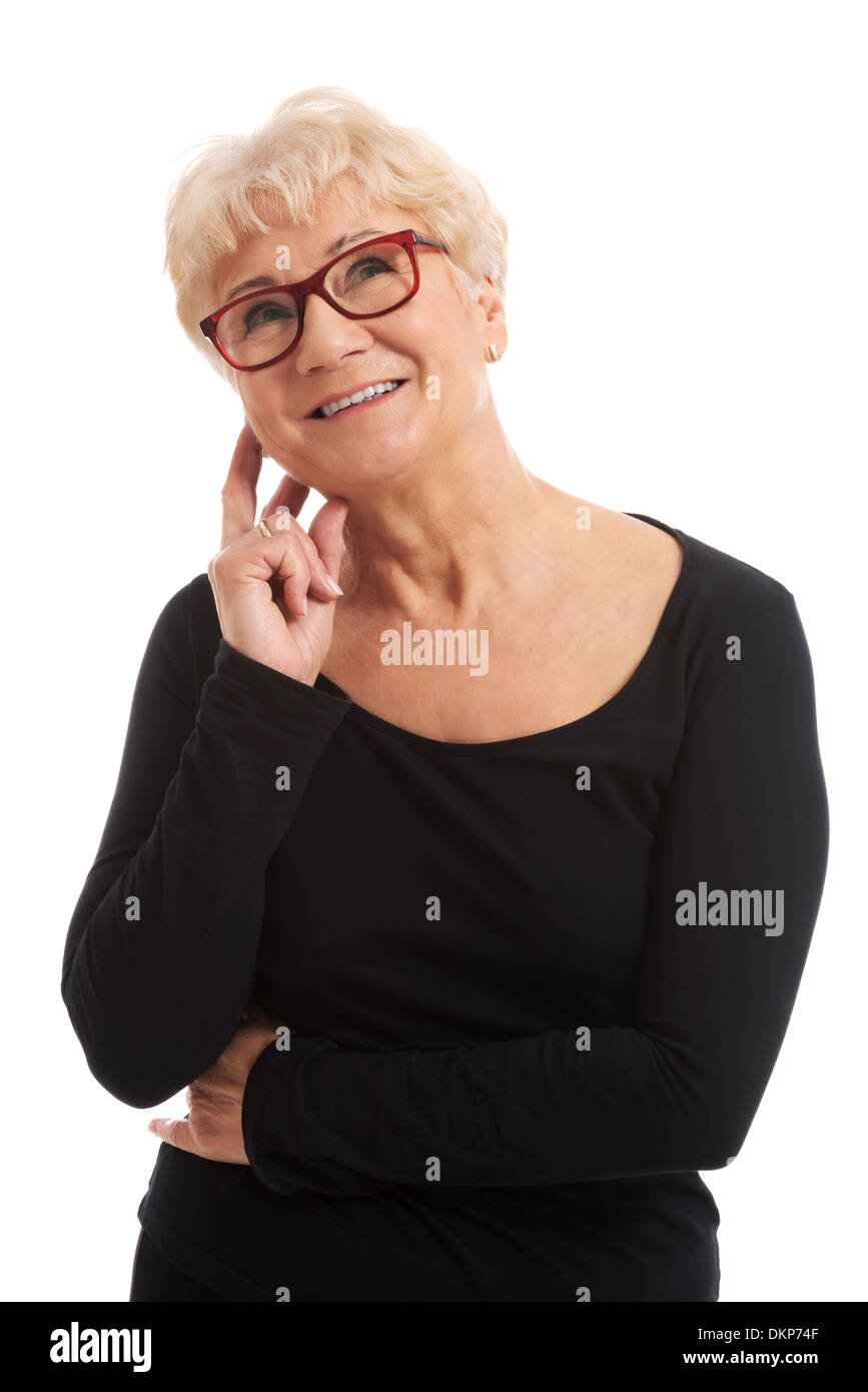 An old lady in eyeglasses touches her face in contemplation. Isolated ...