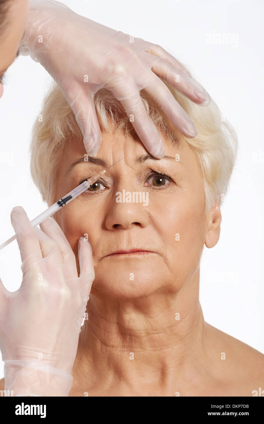 An old woman having a injection- beauty concept. Isolated on white ...