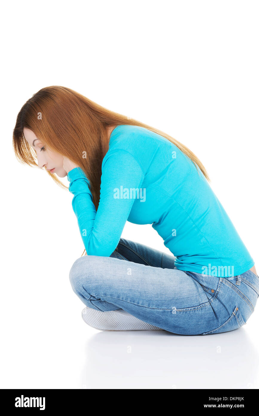 Attractive casual woman sitting with head down. Isolated on white Stock ...