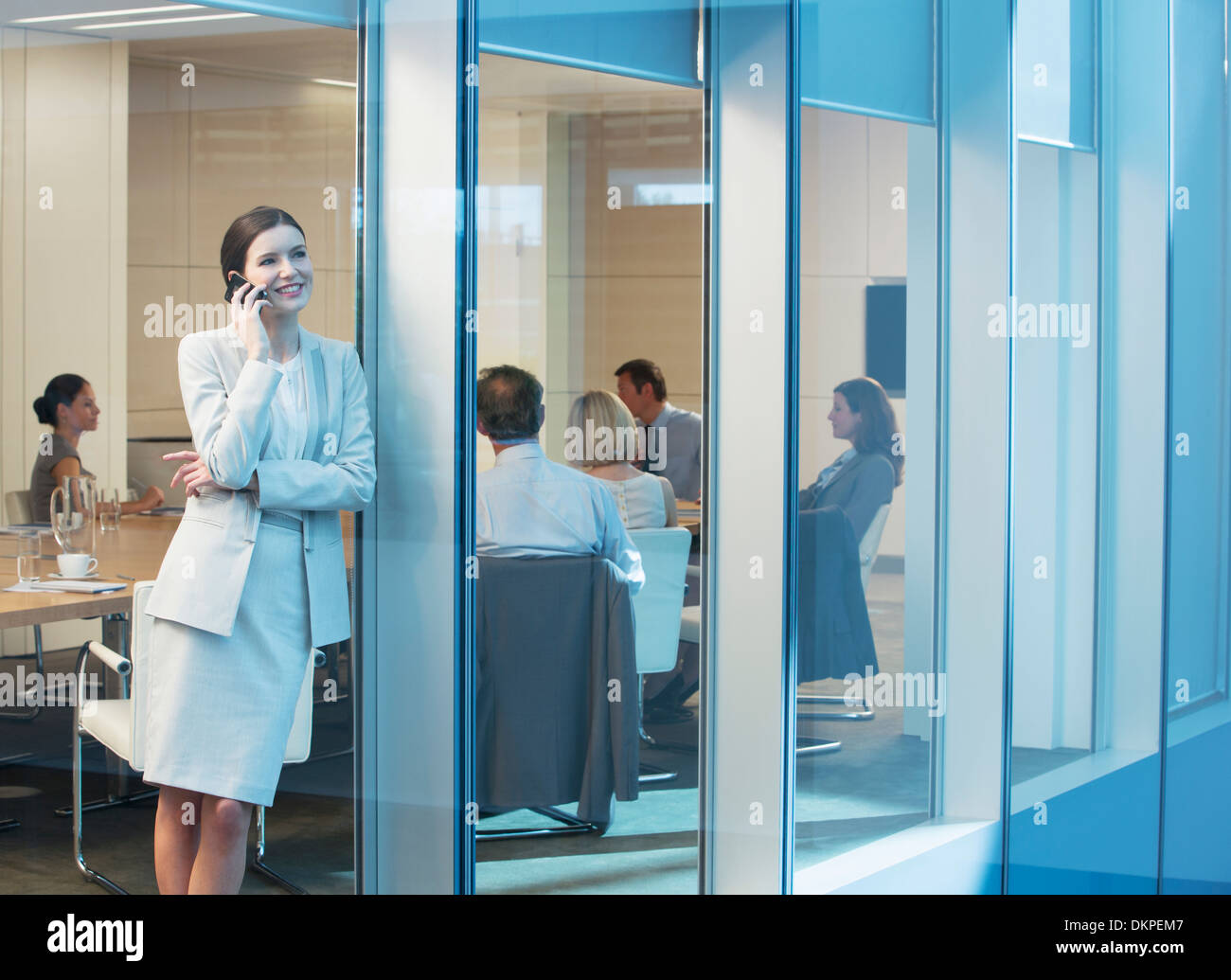 Businesswoman talking on cell phone in meeting Stock Photo - Alamy