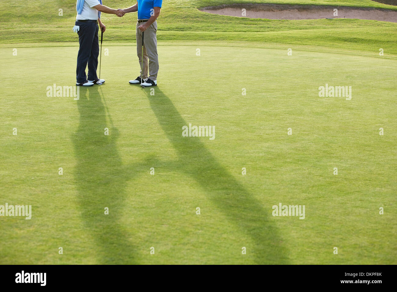 Senior men shaking hands on golf course Stock Photo - Alamy