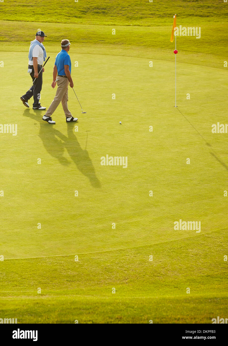 Senior men walking on golf course Stock Photo - Alamy
