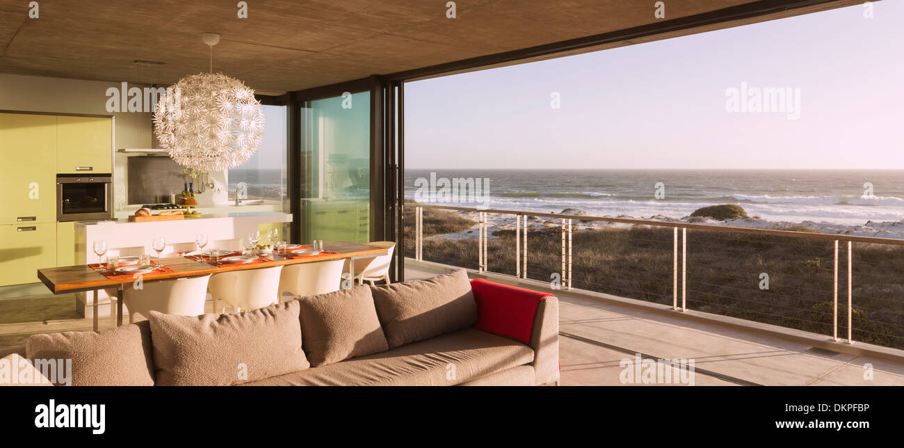 Modern living room and dining room overlooking ocean Stock Photo - Alamy