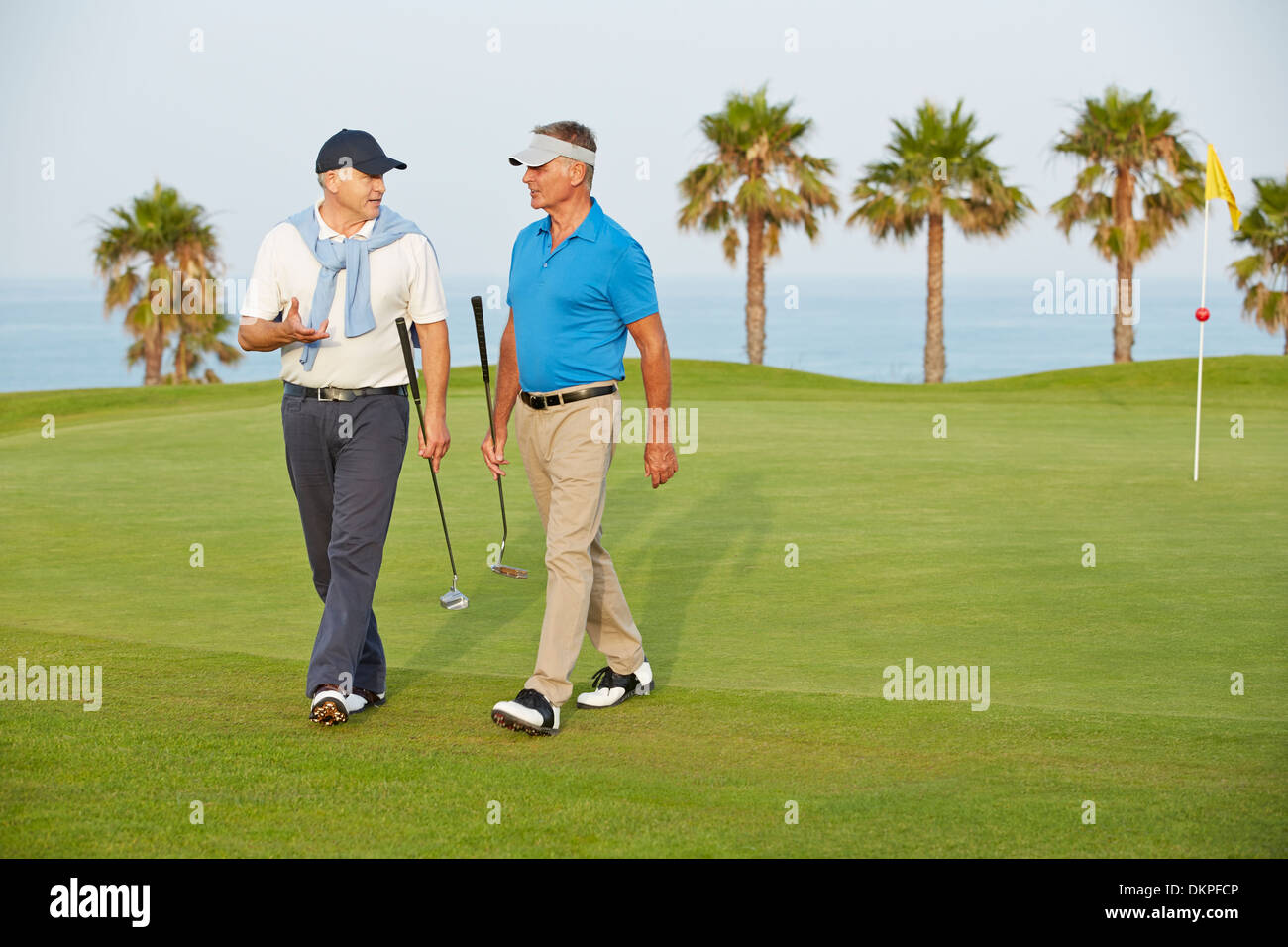 Senior men walking on golf course Stock Photo - Alamy