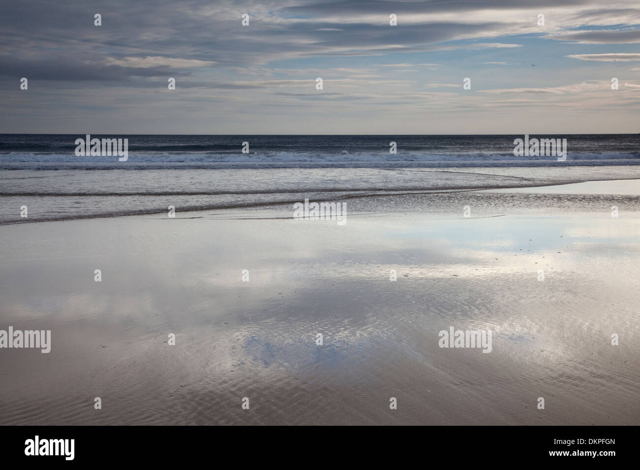 Sun reflecting on beach at low tide Stock Photo - Alamy