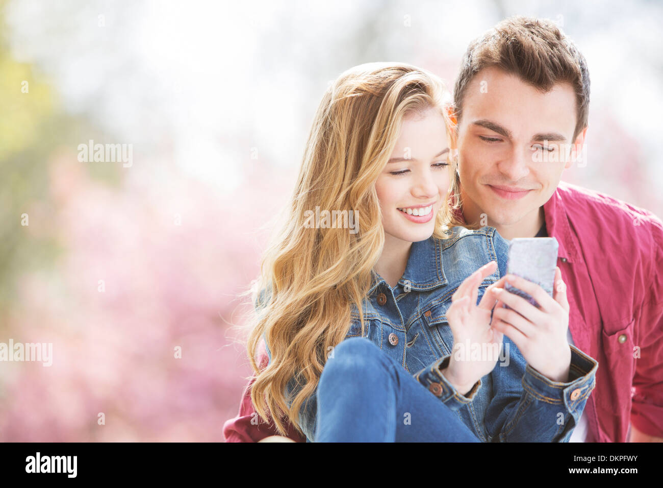 Couple using cell phone outdoors Stock Photo - Alamy