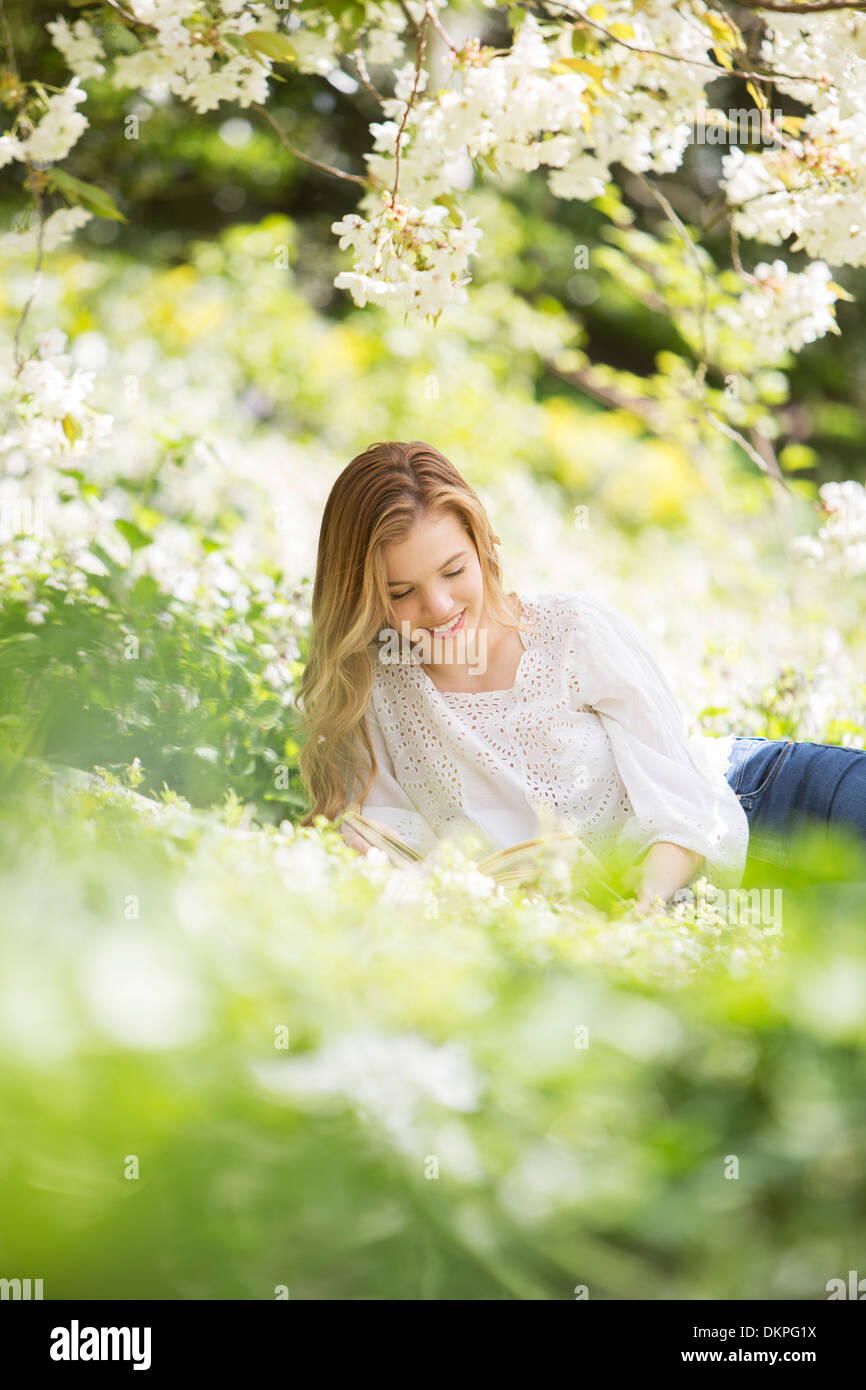 Woman reading under tree hi-res stock photography and images - Alamy