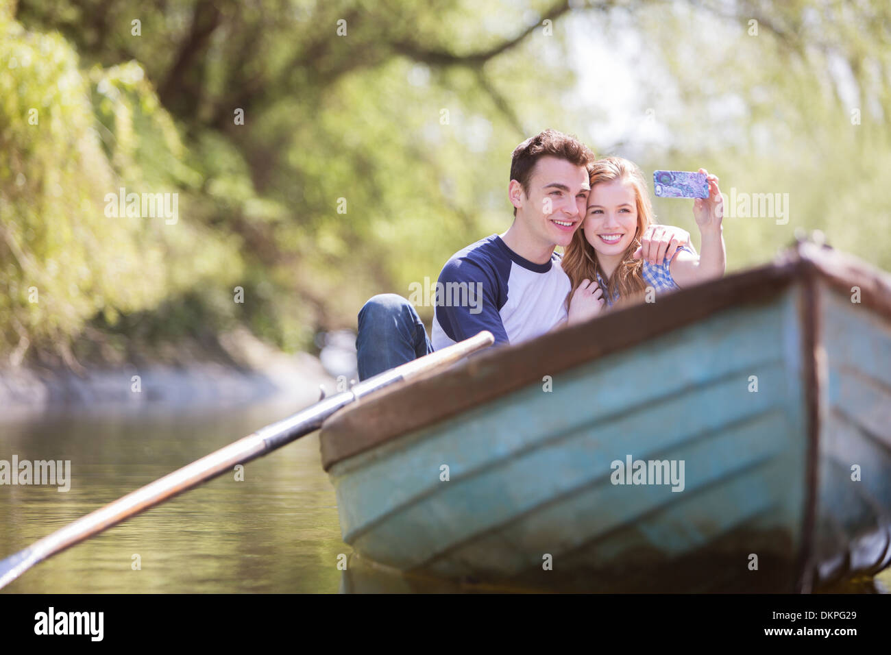 Couple taking self-portraits in rowboat Stock Photo - Alamy