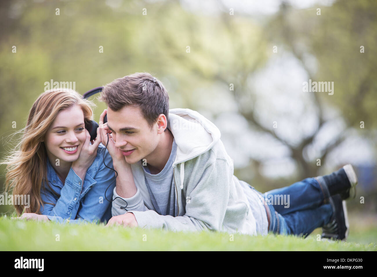 Couple listening to headphones in park Stock Photo - Alamy