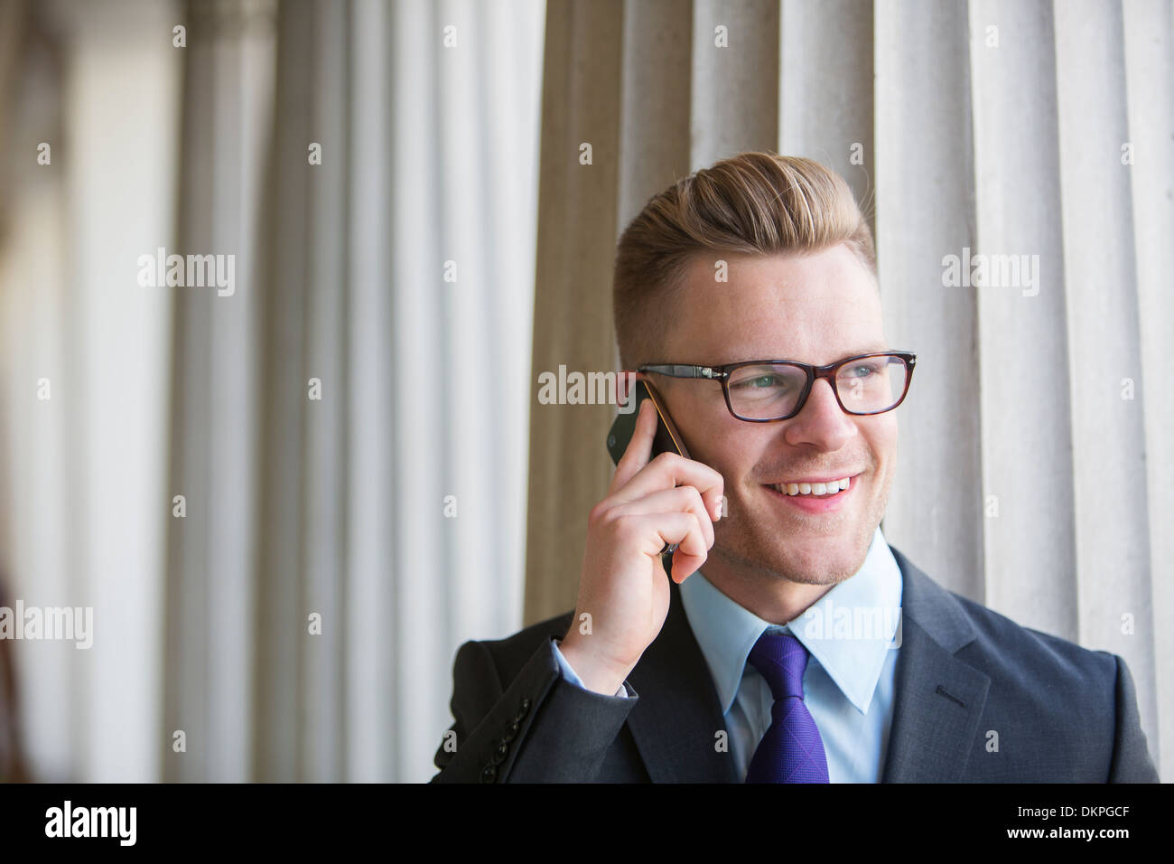 Smiling businessman talking on his cellphone at an office desk Stock ...