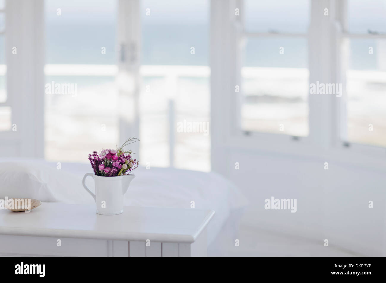 Vase of flowers on desk in bedroom overlooking ocean Stock Photo - Alamy