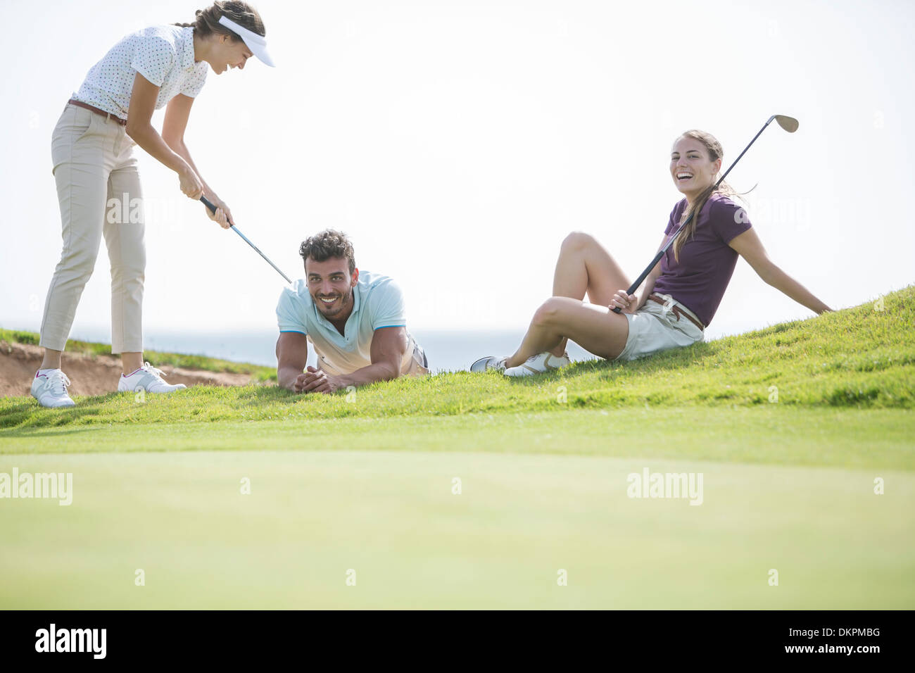 Friends playing on golf course Stock Photo - Alamy