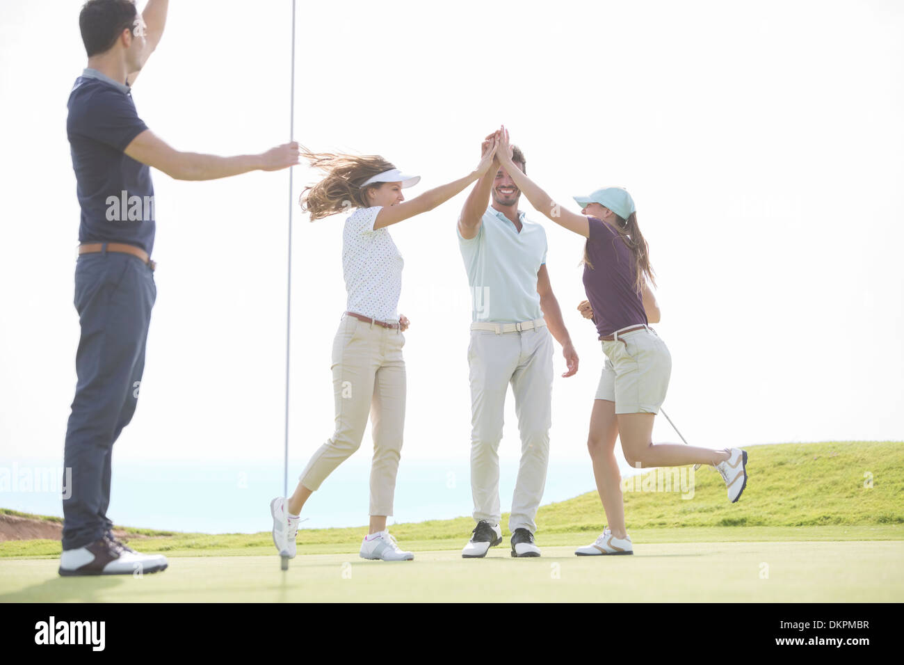 Friends celebrating on golf course Stock Photo - Alamy