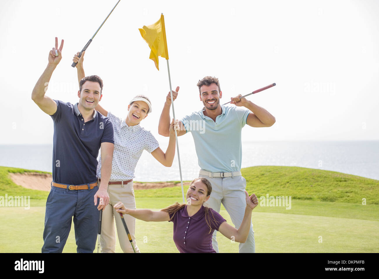 Enthusiastic friends waving on golf course Stock Photo - Alamy