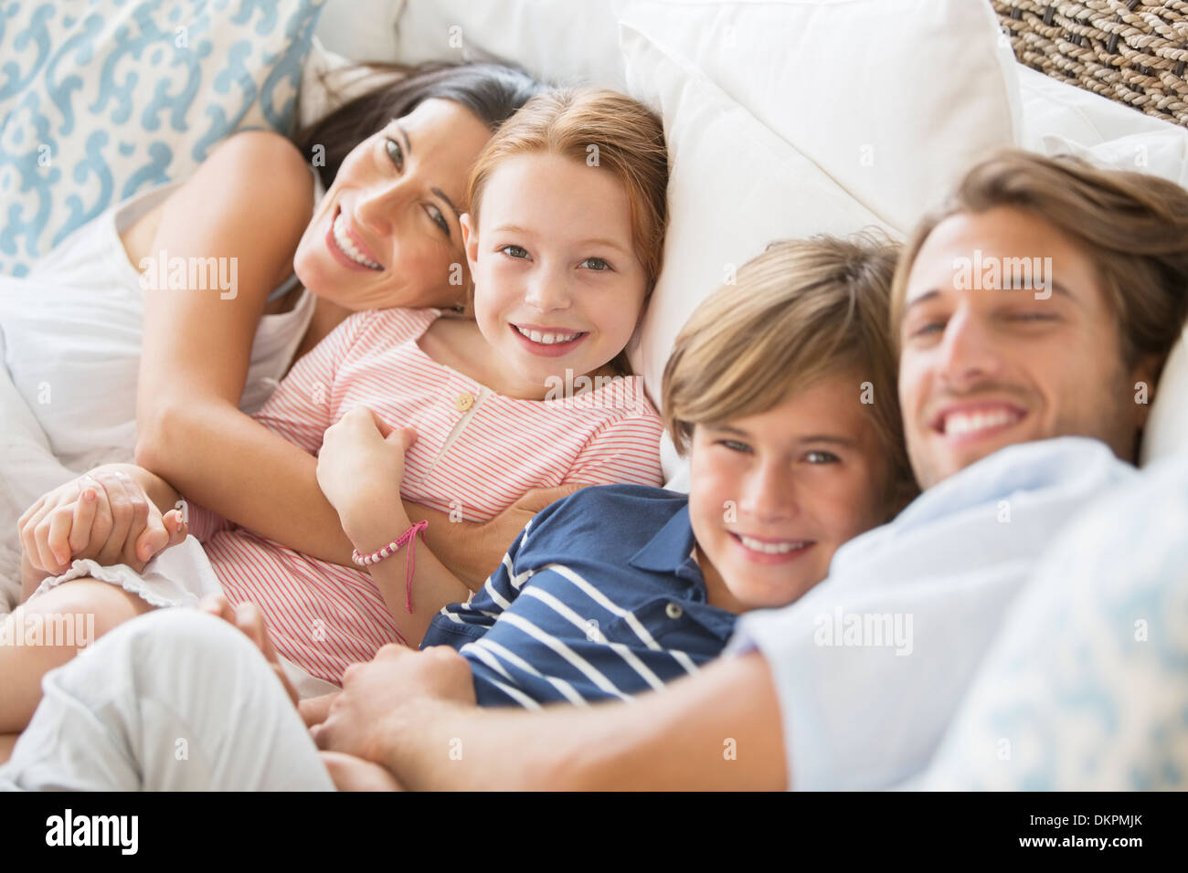 Family relaxing together on sofa Stock Photo - Alamy